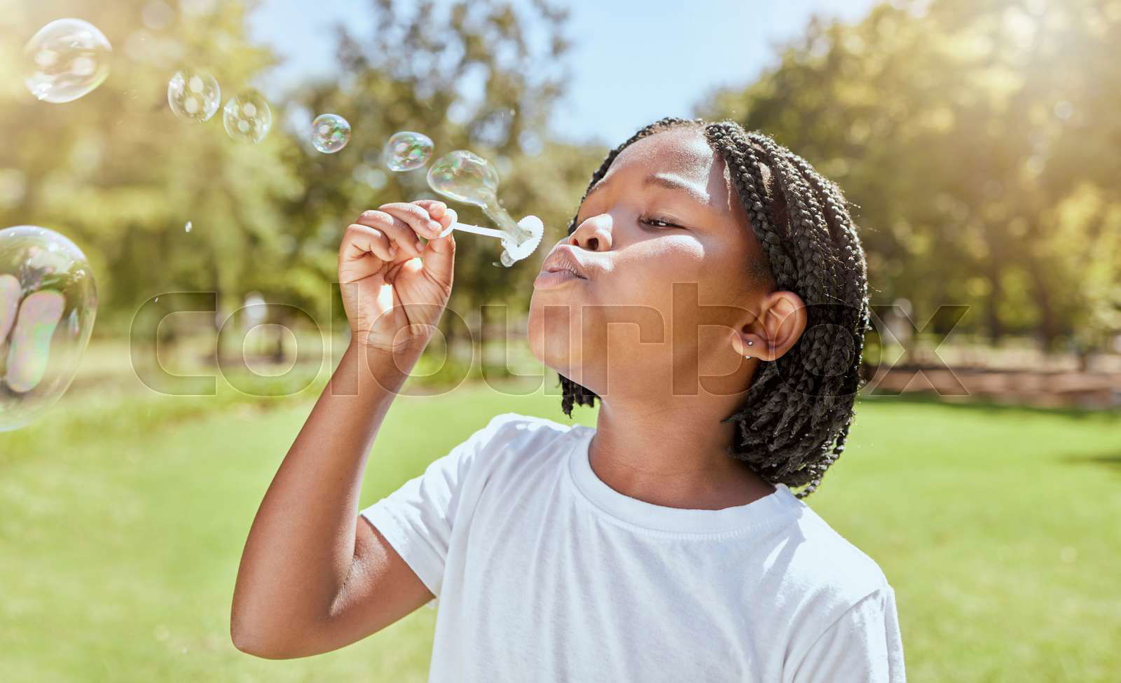 Park child and black girl blowing bubbles enjoying fun time Colourbox